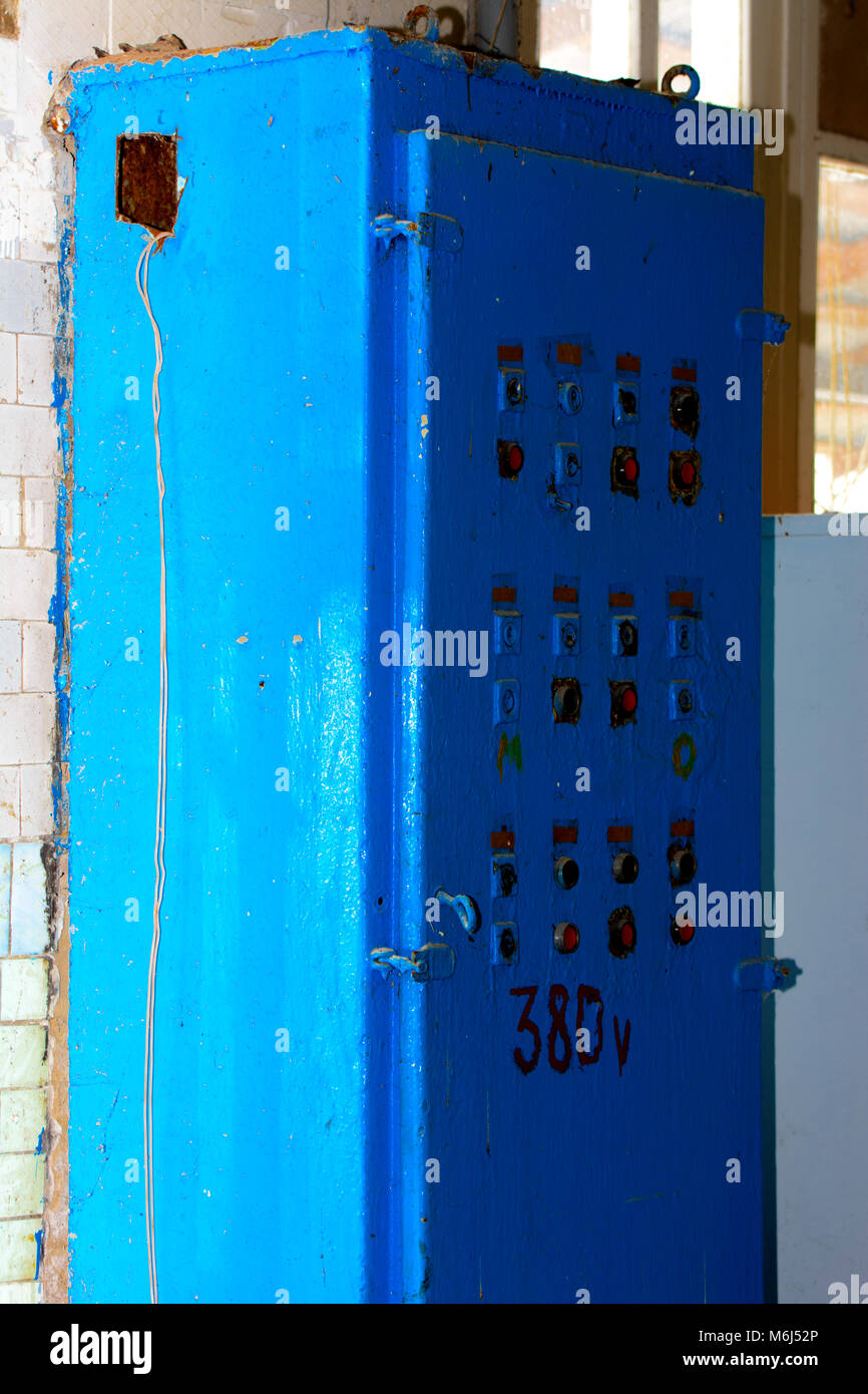 Old dismantled and rusty electrical panel assembly on an abandoned and ...