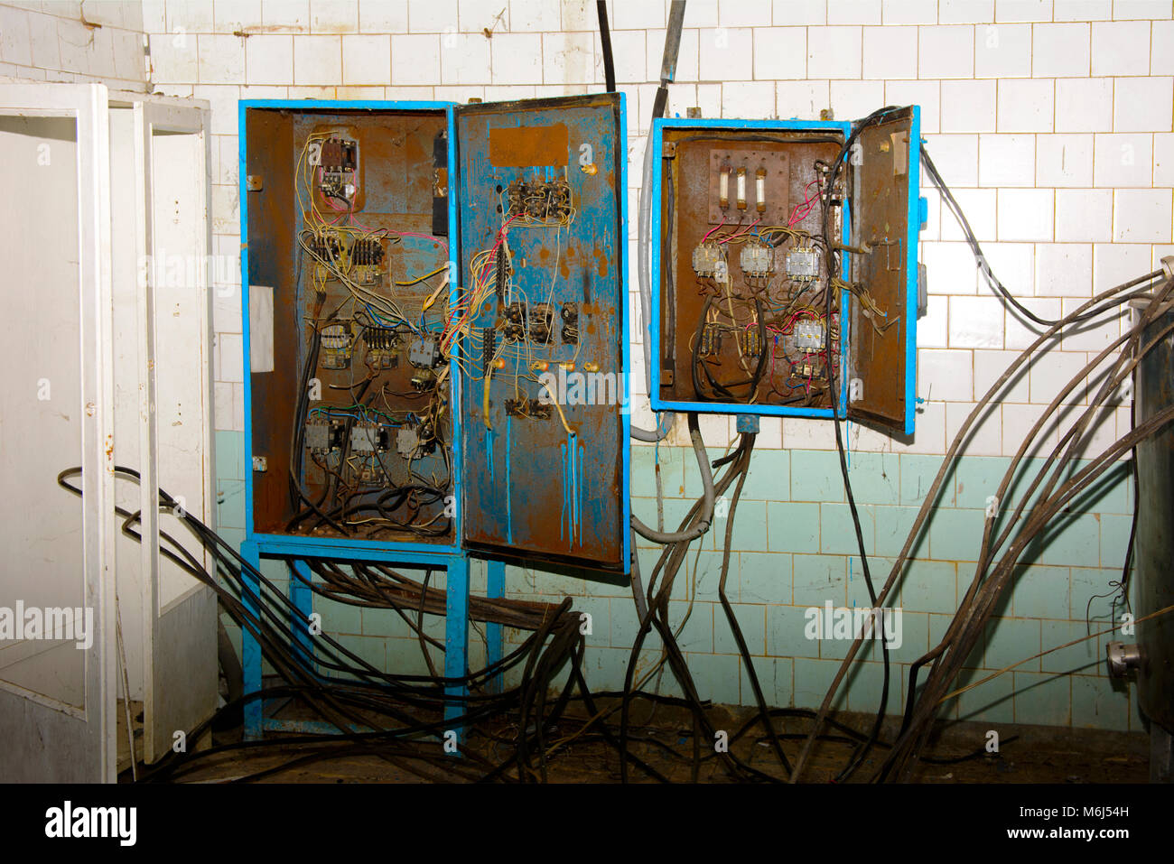Old dismantled and rusty electrical panel assembly on an abandoned and ...