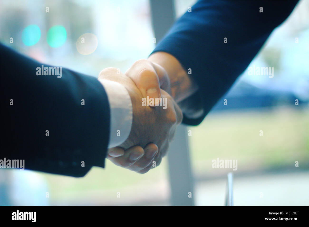 confident handshake of business partners on background of office Stock ...