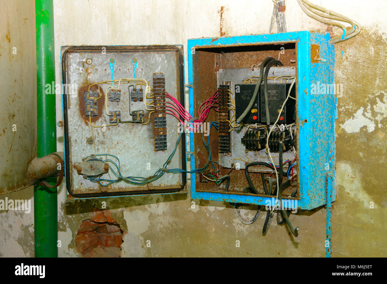 Old dismantled and rusty electrical panel assembly on an abandoned and ...