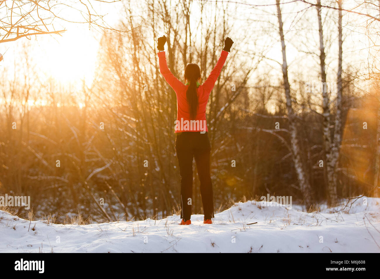 Photo from back of sporty woman with arms raised Stock Photo - Alamy
