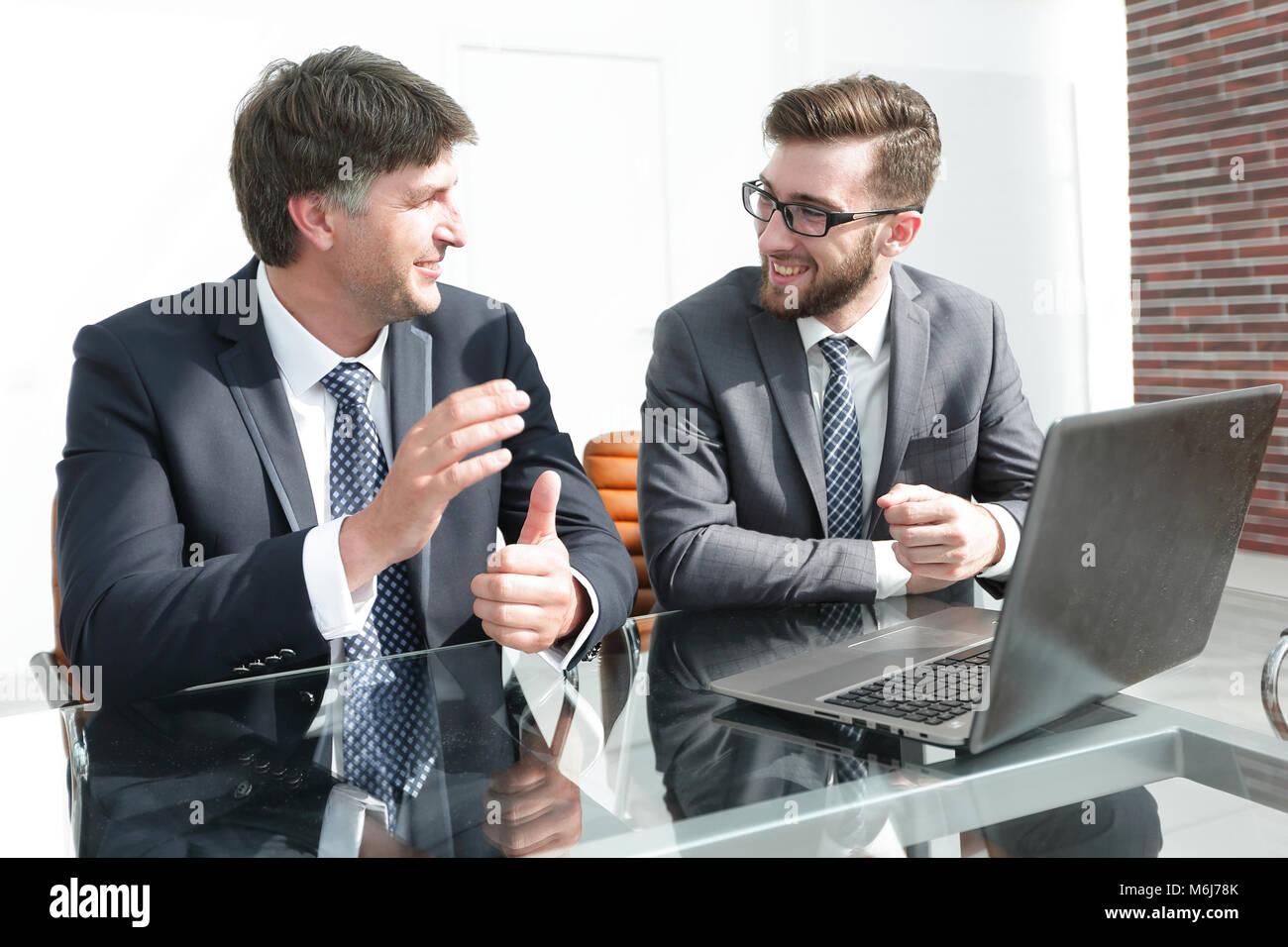 Portrait of two business people sitting at office desk Stock Photo - Alamy