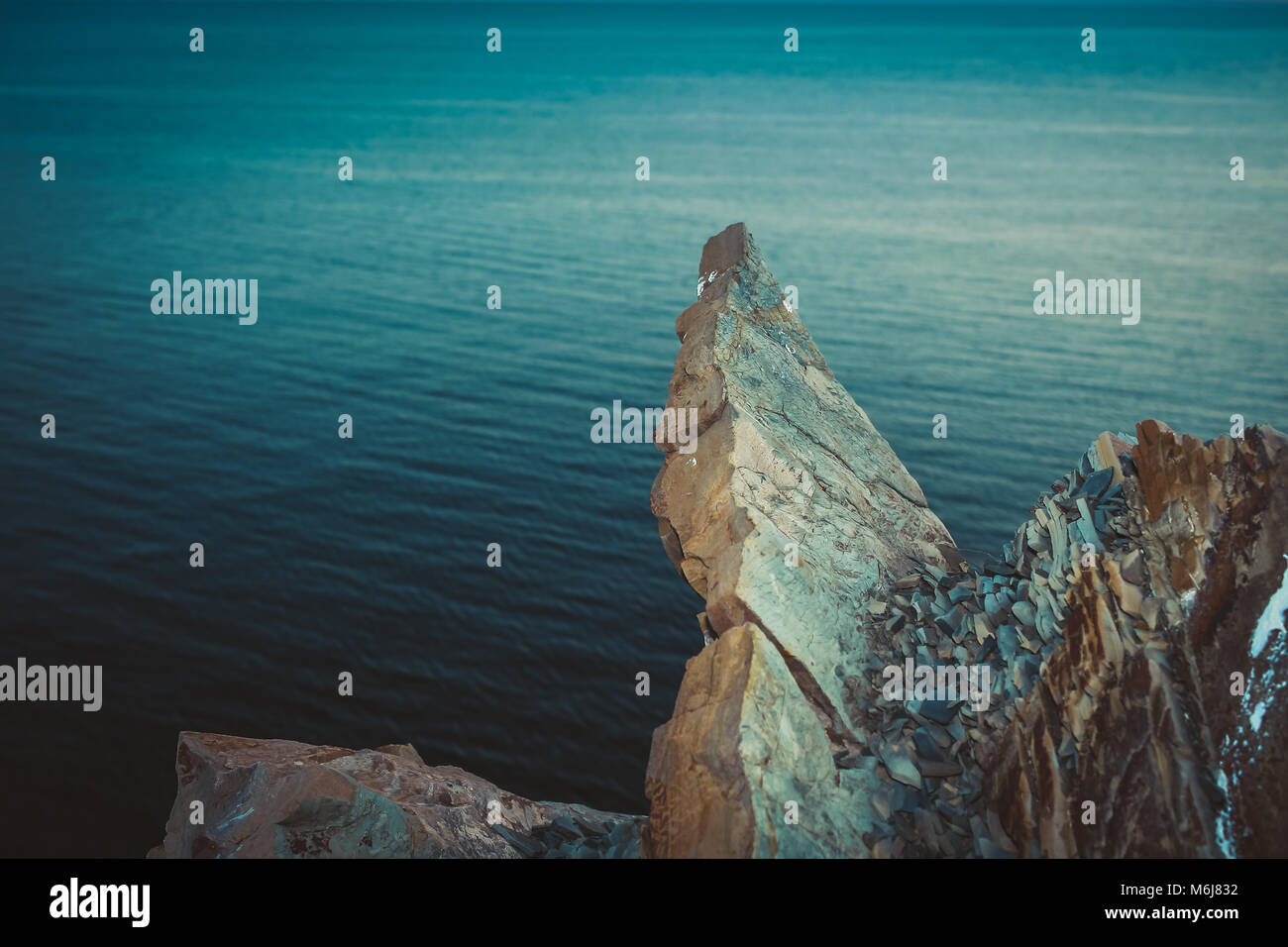 Sharp rocks over water. Blue toned image Stock Photo - Alamy