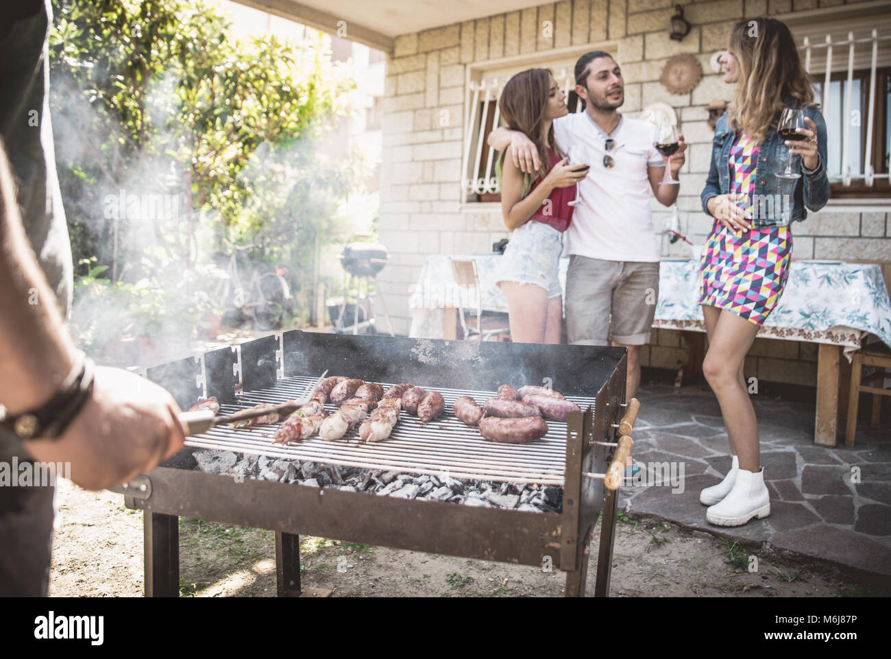 Group of friends making barbeque in the backyard. concept about good and positive mood with ...