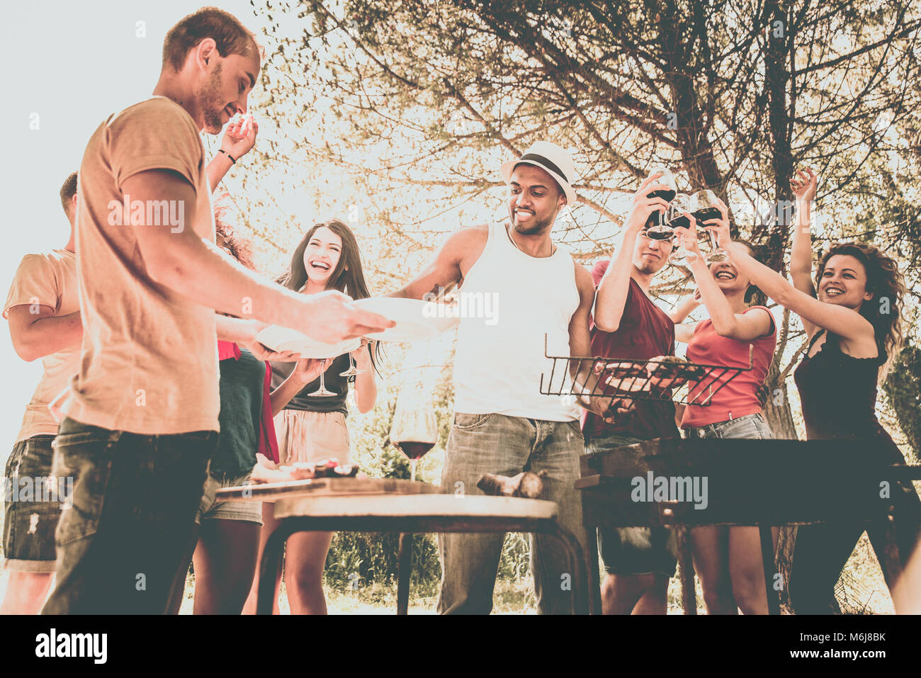 Group of friends making barbecue in the nature. Eating and sharing ...