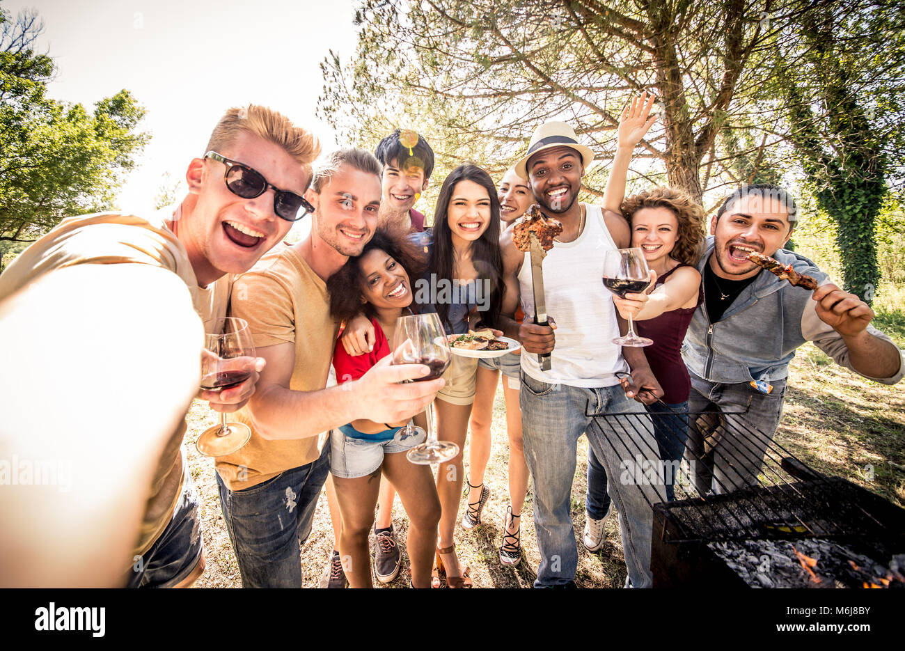 Group of friends making barbecue in the nature. Eating and sharing ...