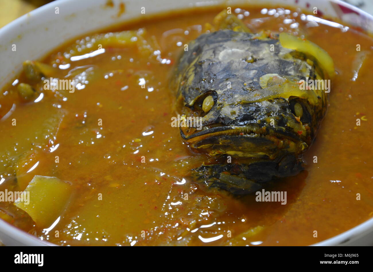 deep fried striped snake head fish in mixed hot and sour soup on bowl ...