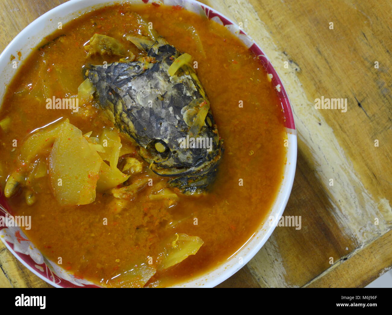 deep fried striped snake head fish in mixed hot and sour soup on bowl ...