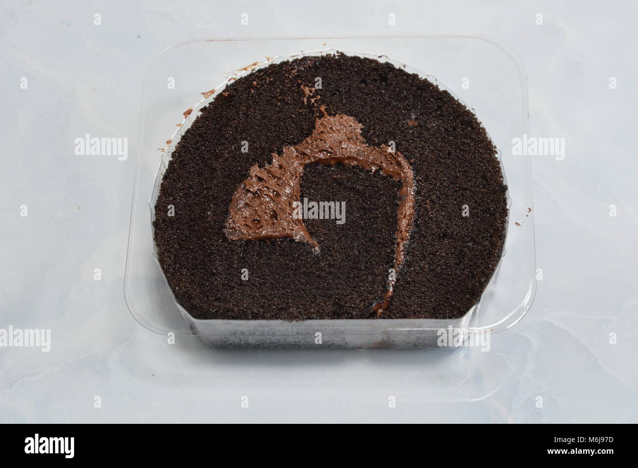 chocolate cake roll on plastic tray Stock Photo - Alamy