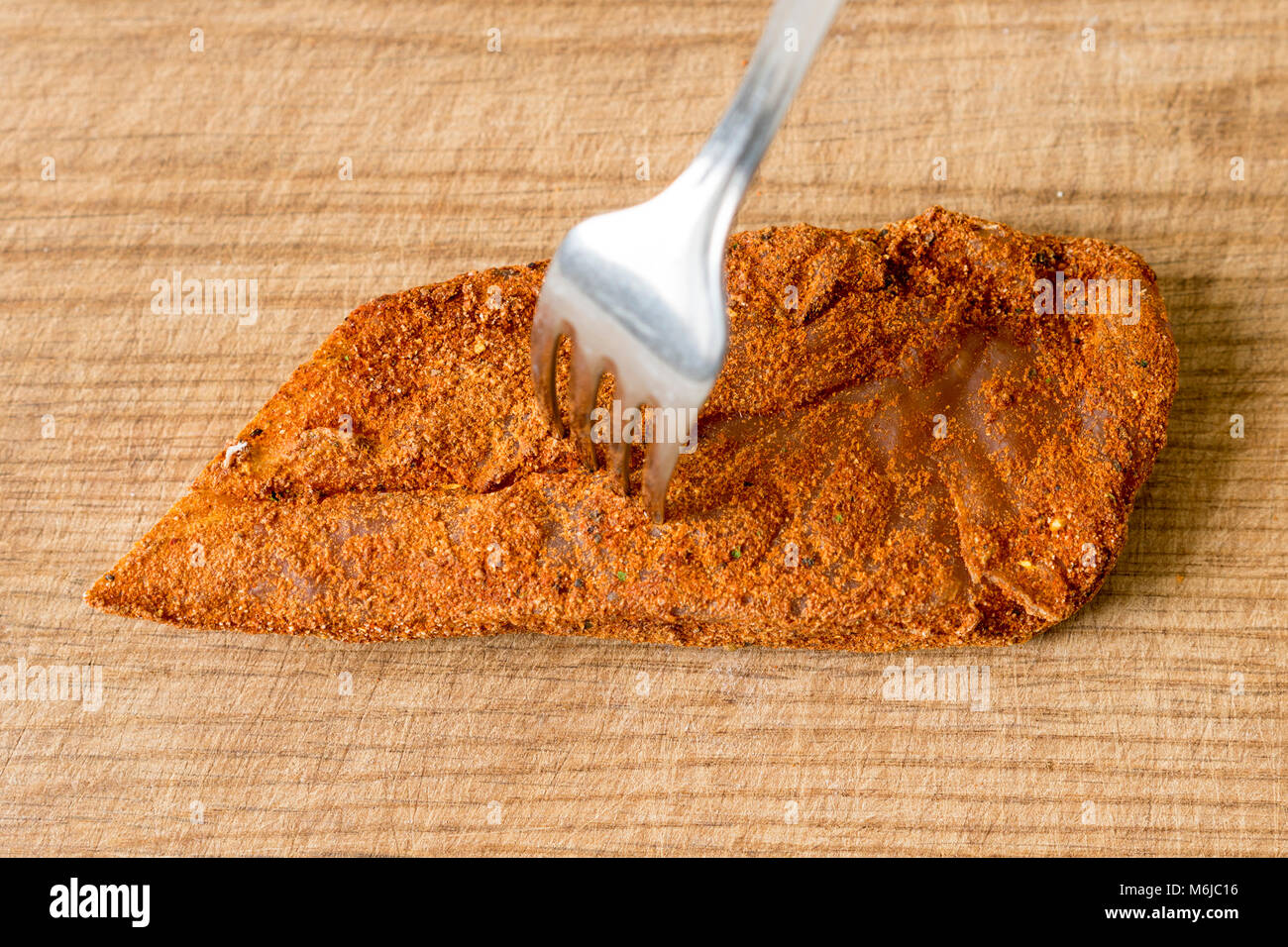 Fork stuck in a piece of meat Stock Photo - Alamy