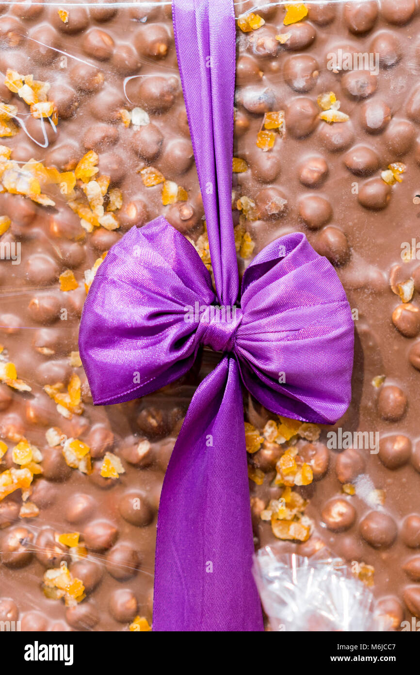 A huge chocolate bar tied with a ribbon. Sweet gift. Milk chocolate ...