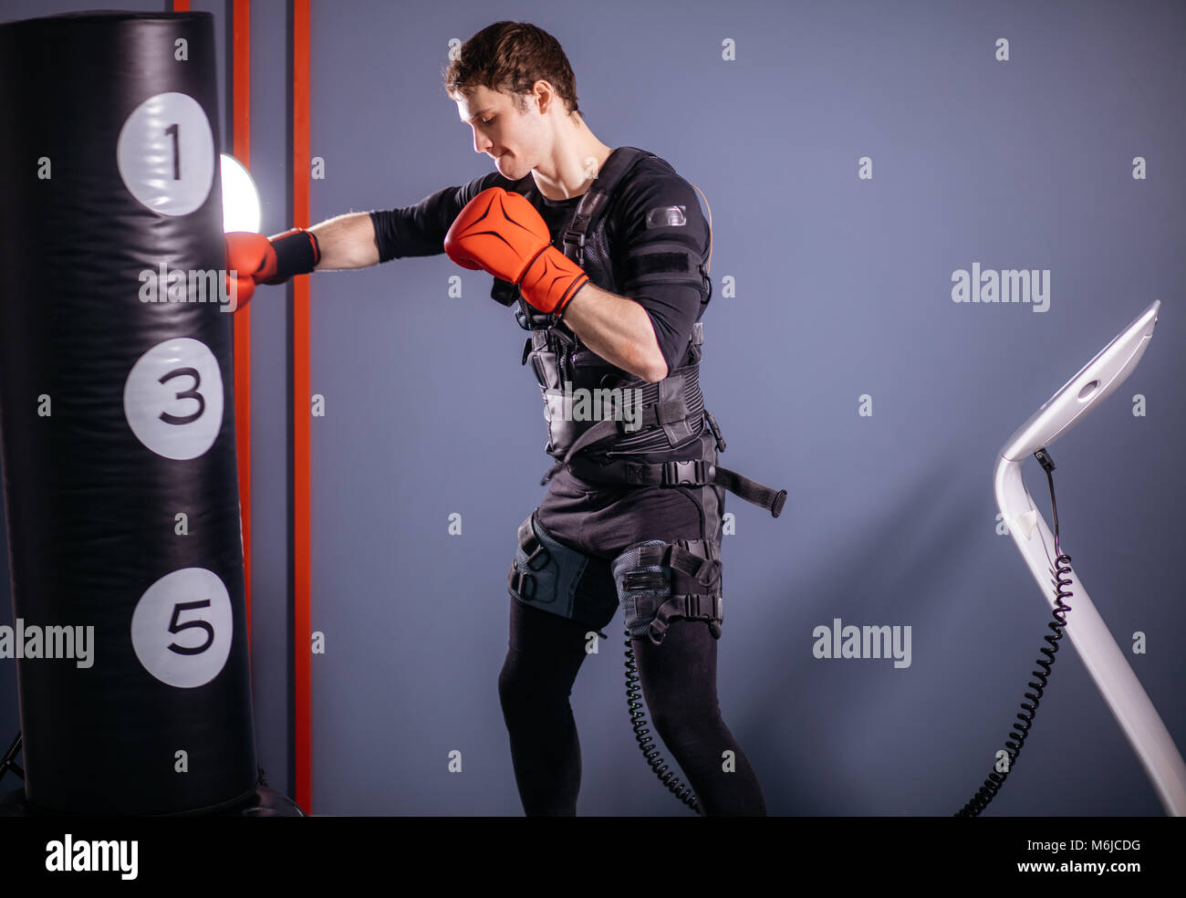 man in boxing gloves during training. boxer in suit of electric ...