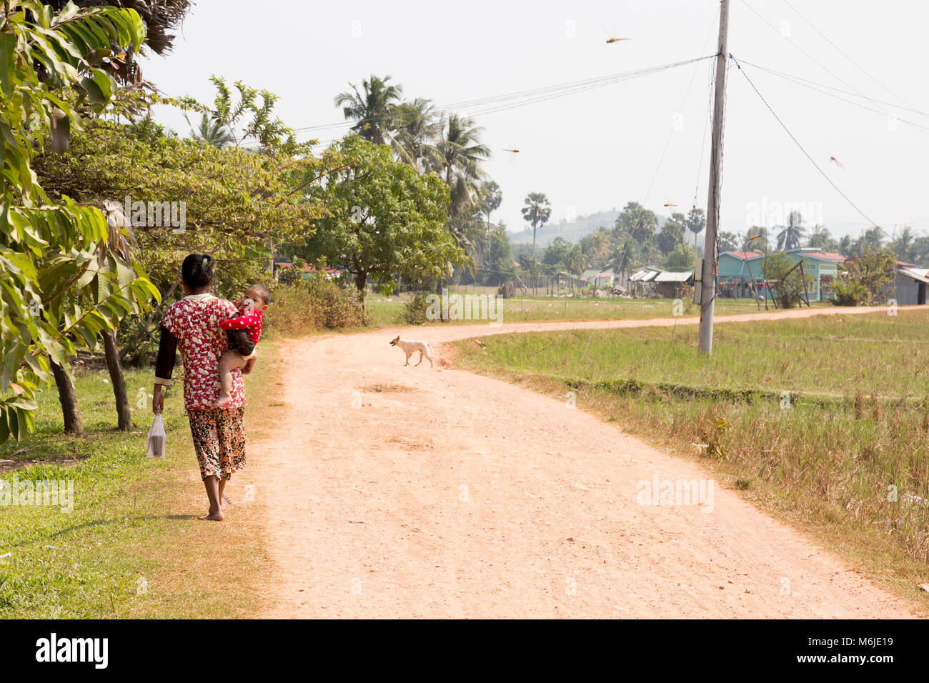 Woman and baby walking in rural Cambodia countryside, Kampot province ...