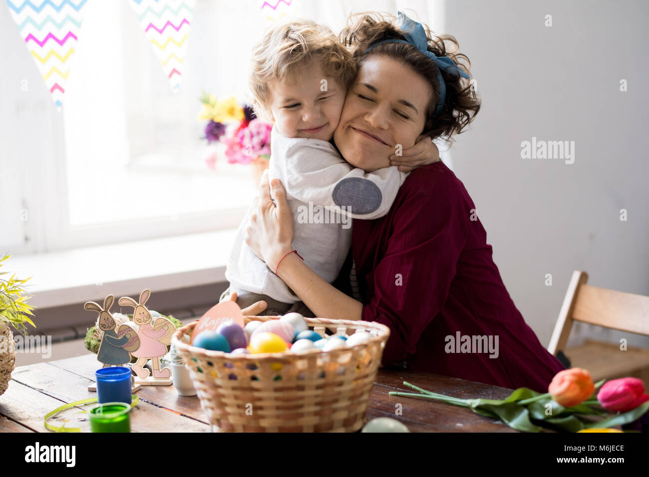 Portrait of pretty young mother hugging little boy tightly with eyes ... Portrait of pretty young mother hugging little boy tightly with eyes ...