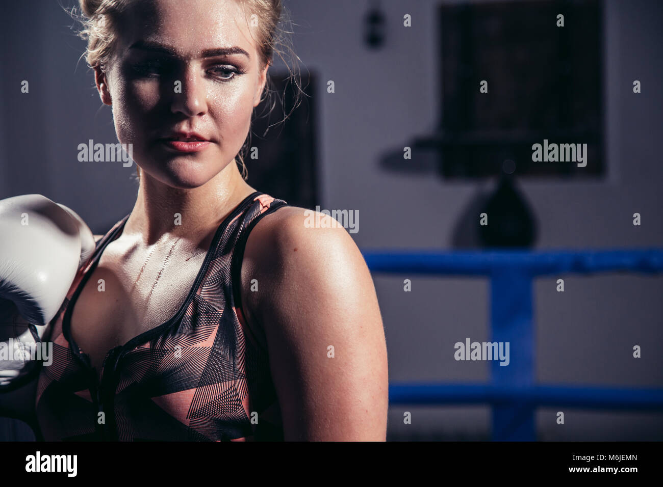 Female Boxer wearing gloves posing in boxing studio Stock Photo - Alamy