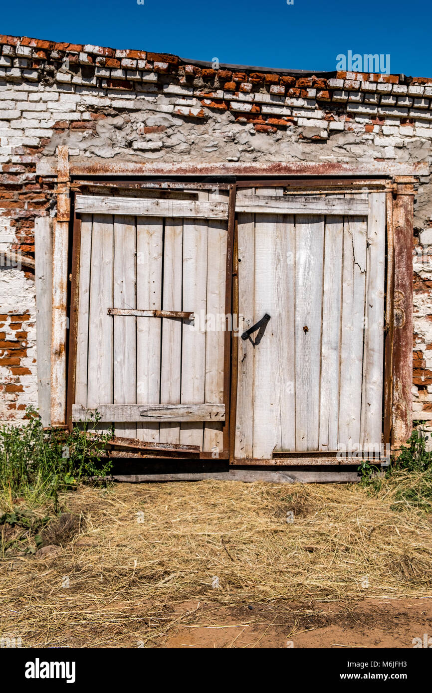 Abandoned old cowshed of weathered brick wall and with dilapidated ...
