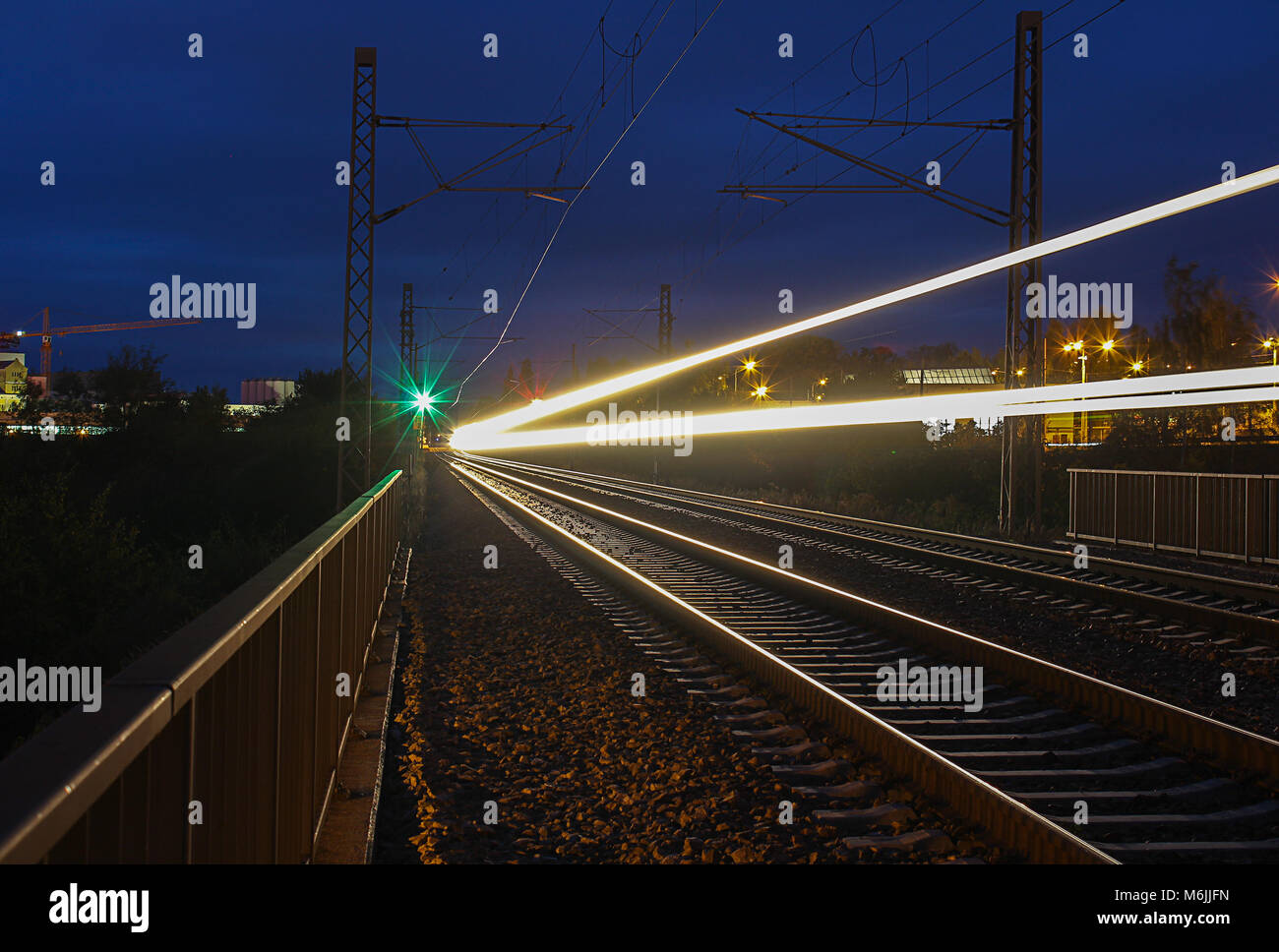 Train trails in night on long exposure with green light Stock Photo - Alamy