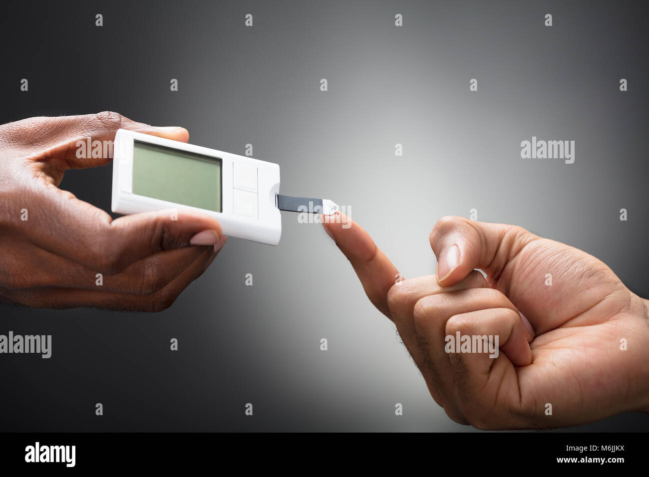Close-up Of Doctors Hands Using Glucometer On Finger To Check Blood ...