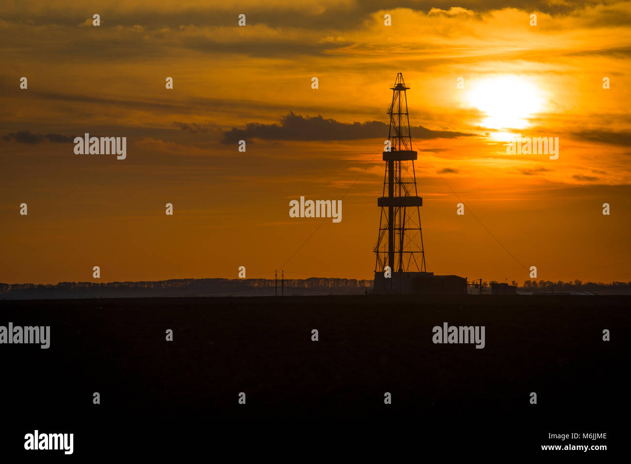 Ukraine, sunset over the drilling rig on an oil&gas field near Okhtyrka ...