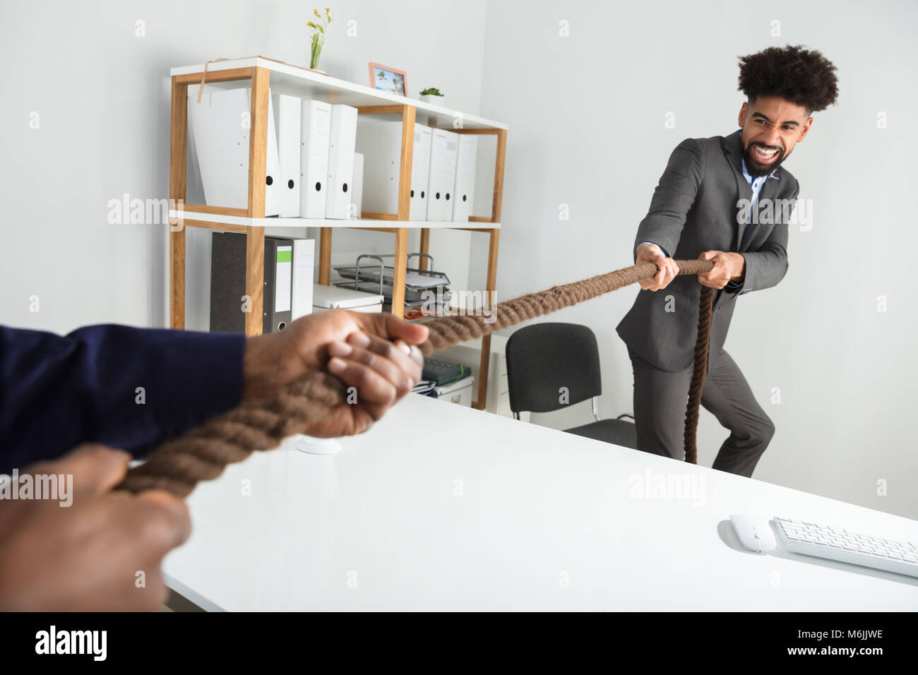 Two Businessmen Pulling Rope In Opposite Direction Stock Photo - Alamy