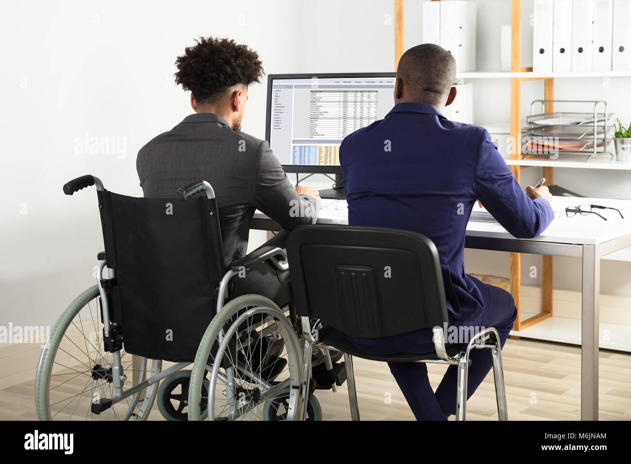 Rear View Of Physically Impaired Businessman With His Partner Working ...
