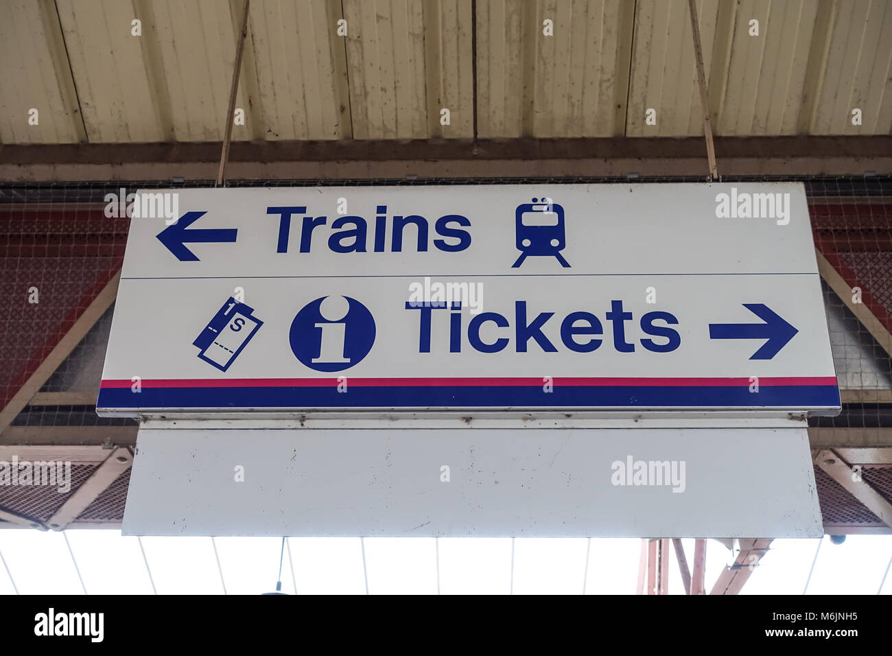 A sign hanging from the roof at a railway station giving directions to ...