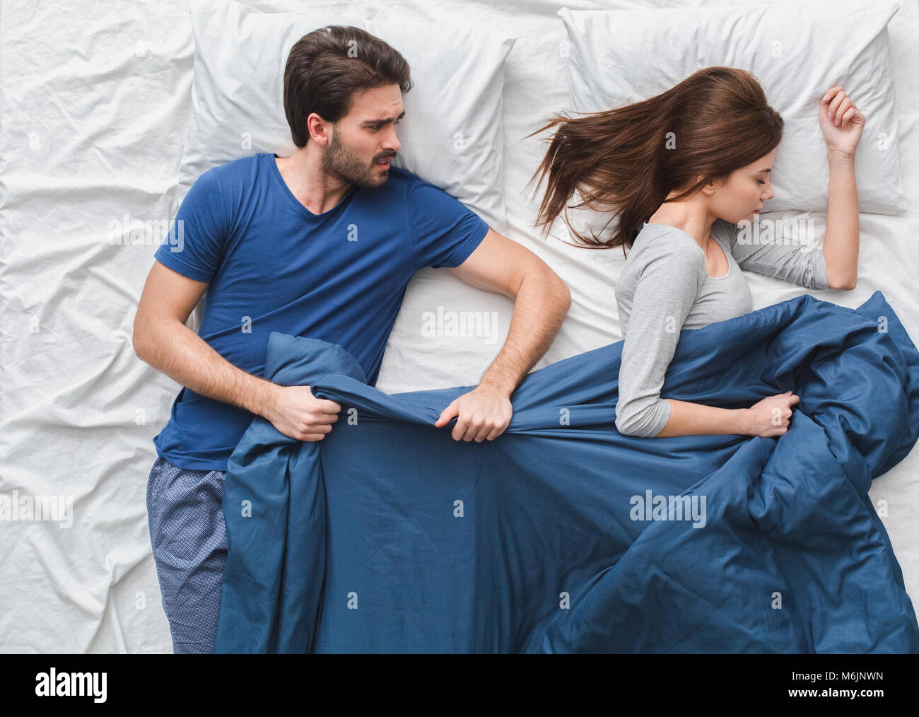 Young couple in bed top view morning concept taking blanket Stock Photo ...