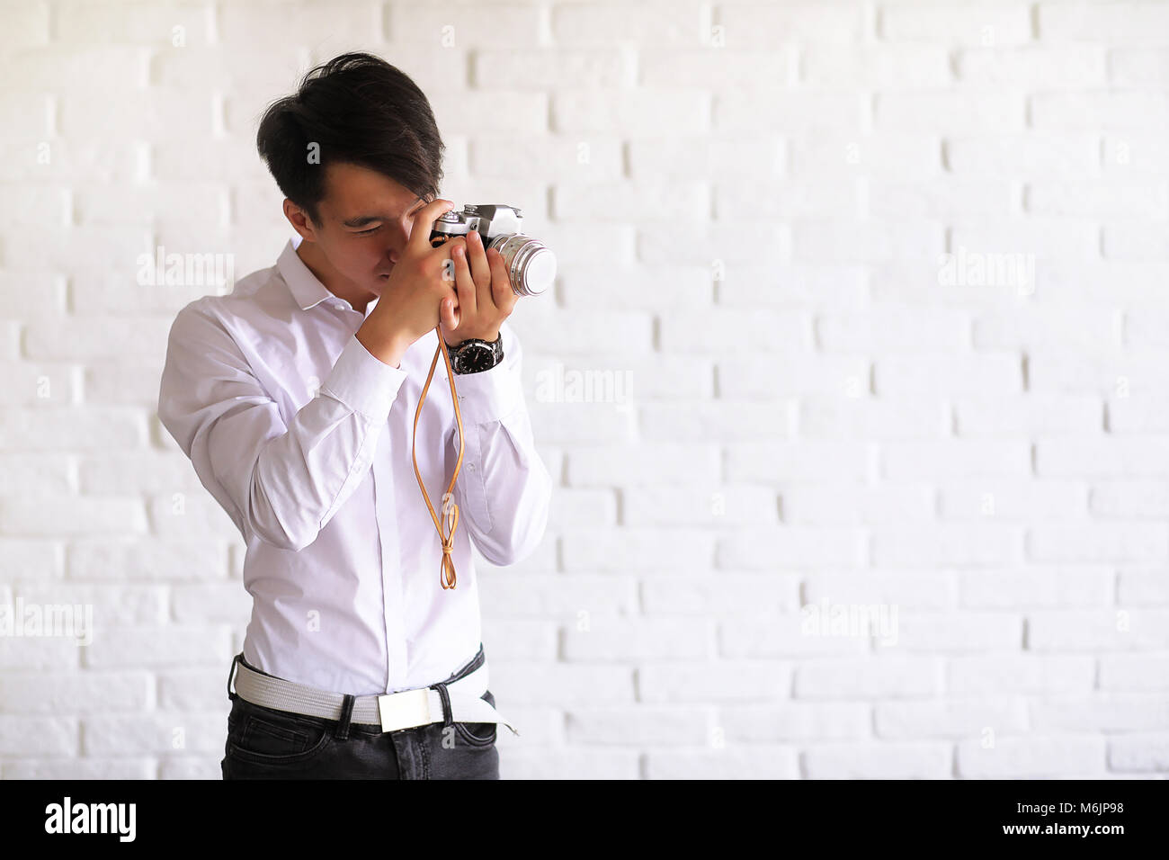 Asian young man with a camera Stock Photo - Alamy