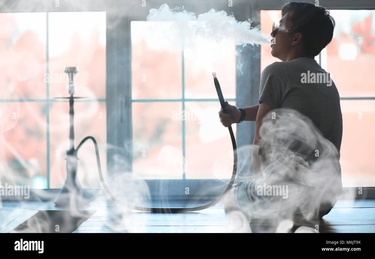 Man in sunglasses smoking a hookah Stock Photo - Alamy