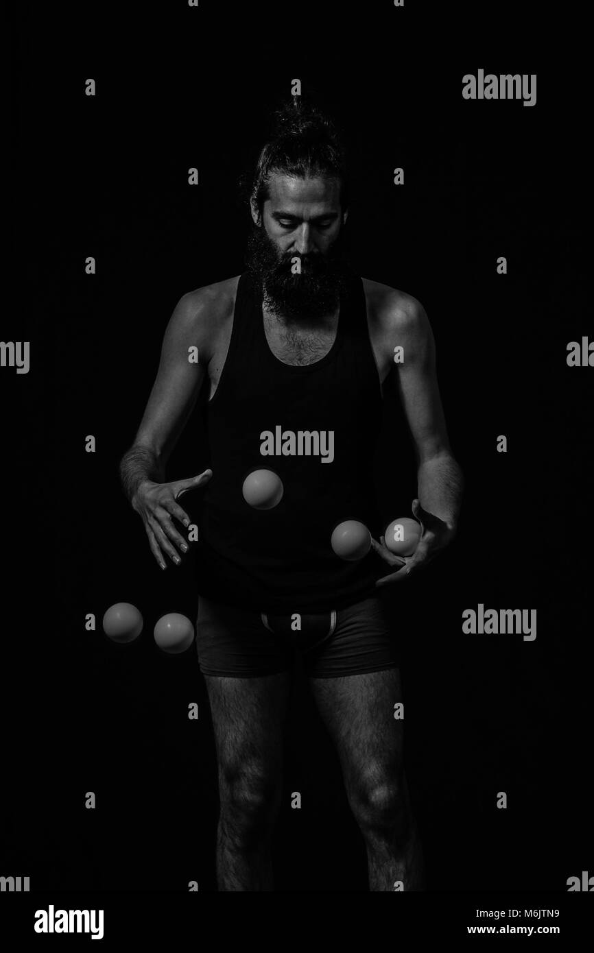 Man fully focused on his juggling performance at the circus ...