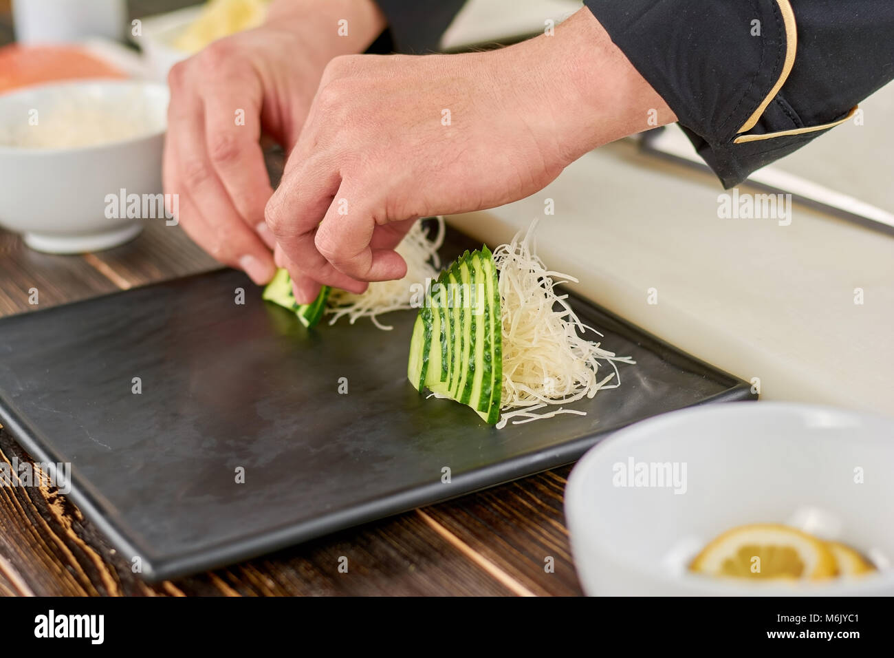 Chef decorating plate with sliced cucumber Stock Photo - Alamy