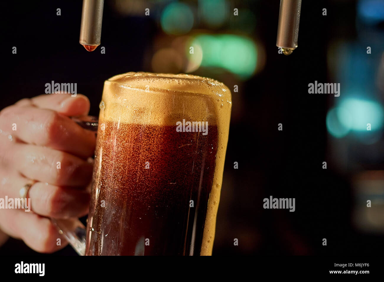 Bartender hand pouring fresh beer Stock Photo - Alamy