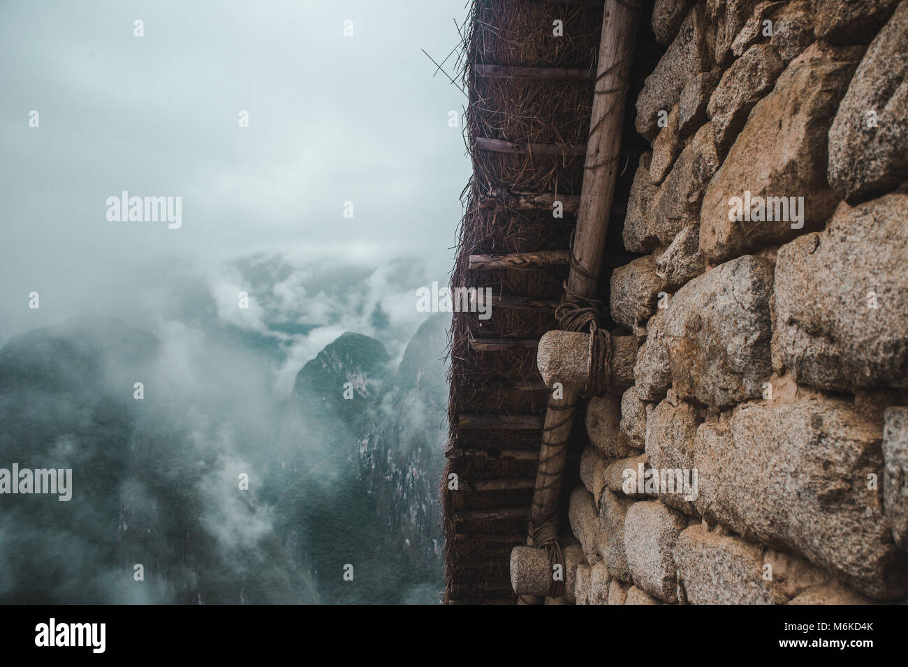Perfectly preserved ancient stone Inca house with straw roof and blue ...
