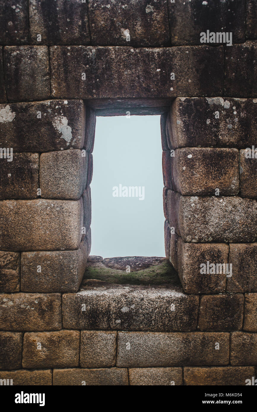 Perfectly preserved ancient stone Inca house with a window on a misty ...