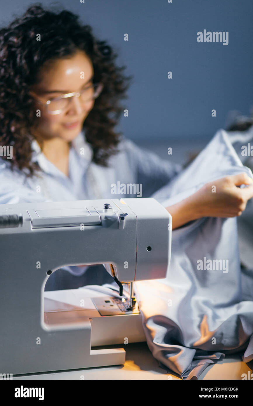 vertical shot of modern sewing machine, dressmaker is behind it Stock ...