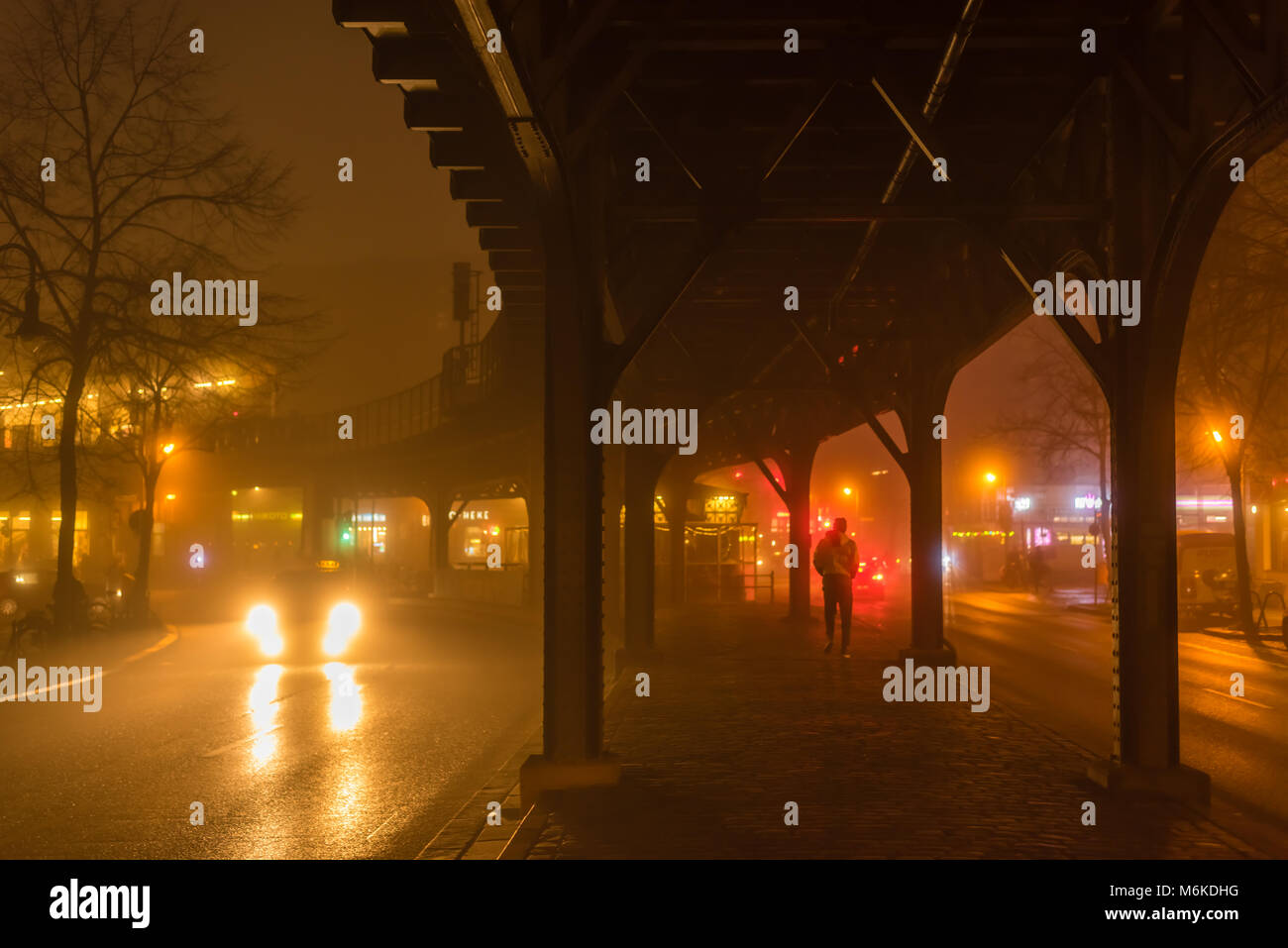 the guy with a yellow jacket under a elevated railway Stock Photo - Alamy