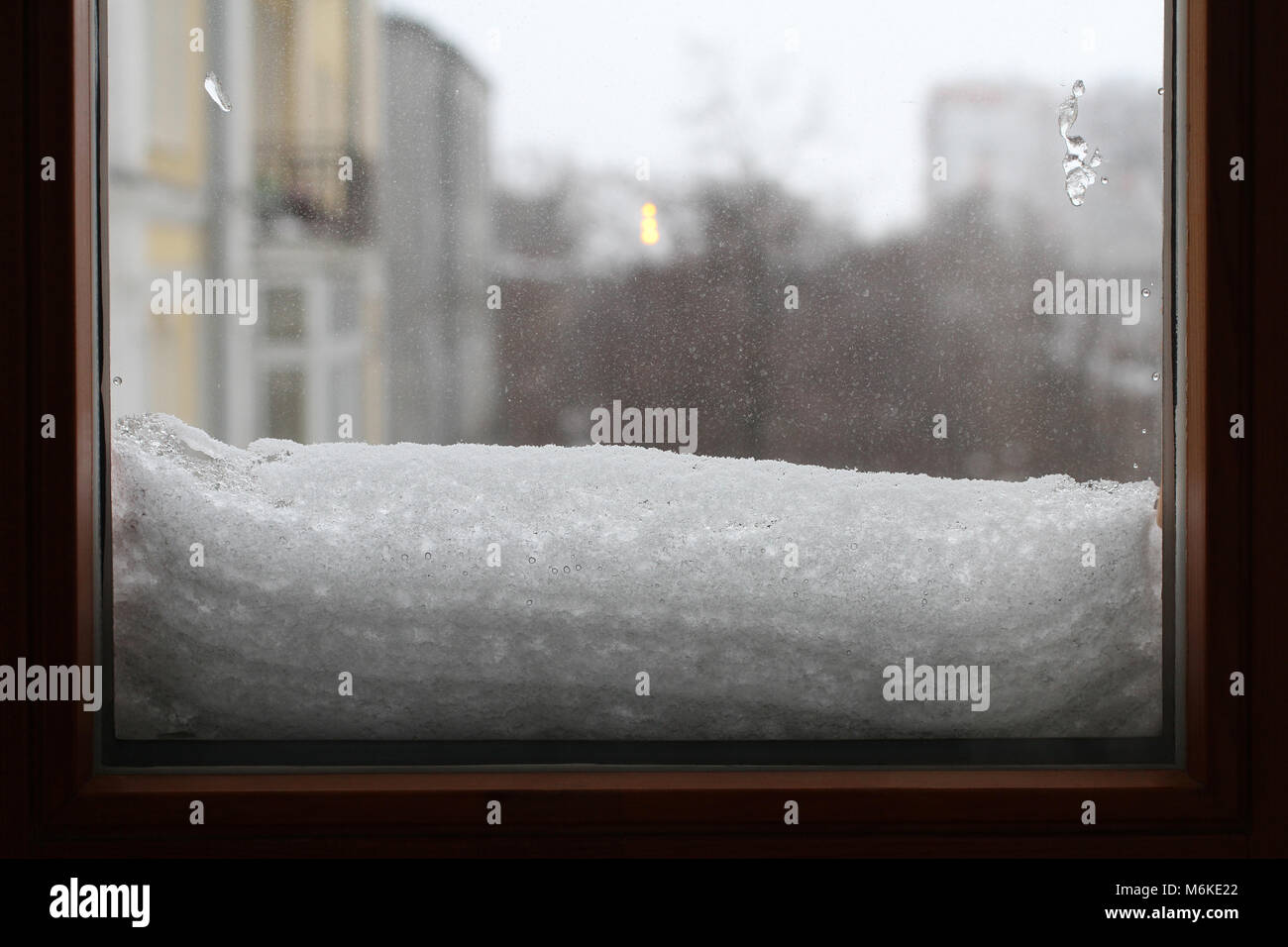 Street view from the room on a dull cloudy winter day. Snow sticking on the outside of the ...