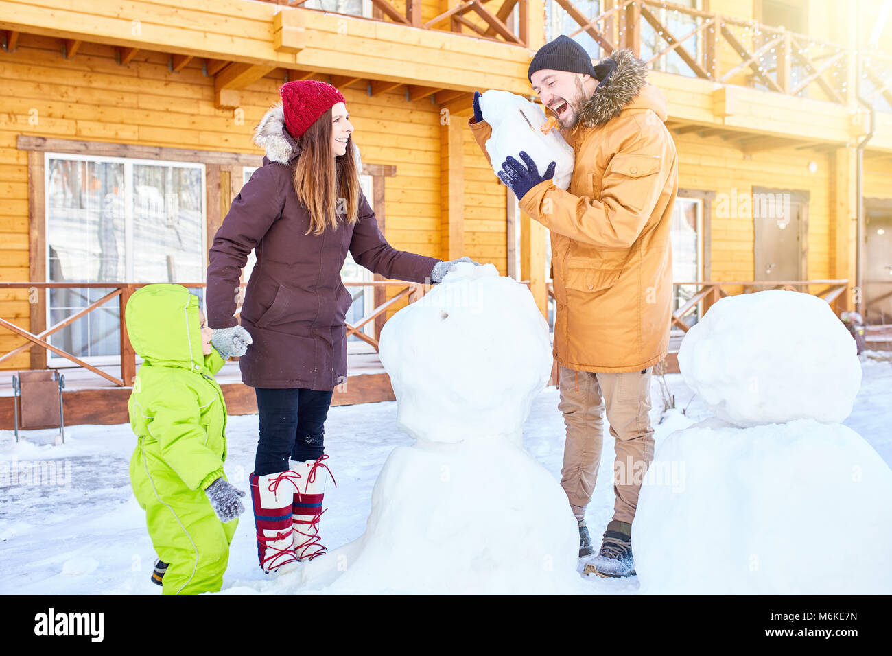 Happy family making snowman Stock Photo - Alamy
