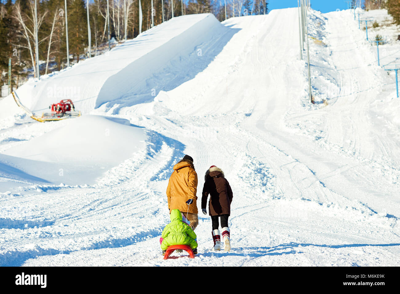 Family walking on snow hill Stock Photo - Alamy