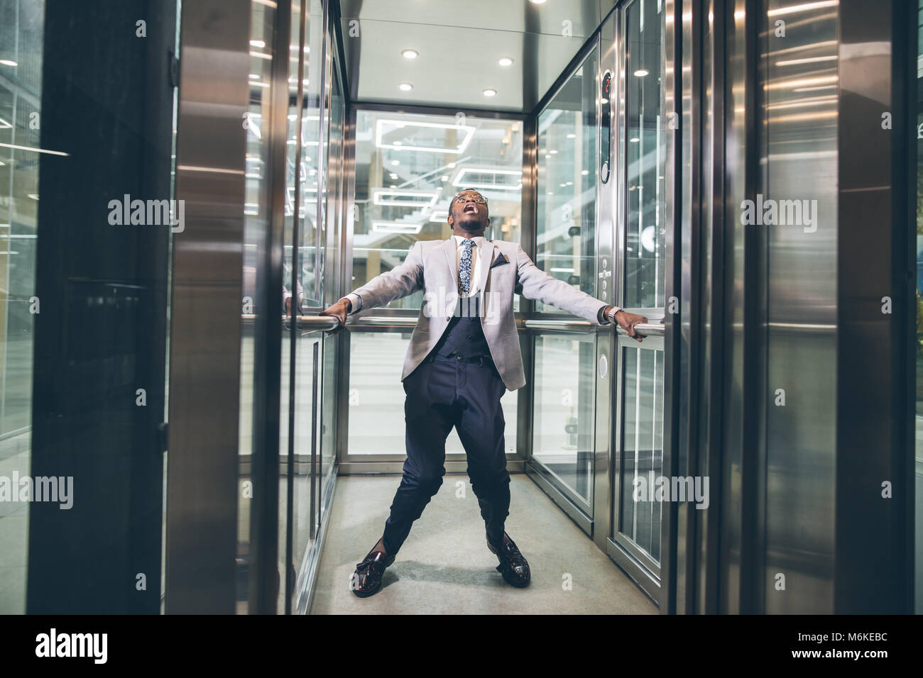 african Businessman screaming in elevator. fear claustrophobia concept ...