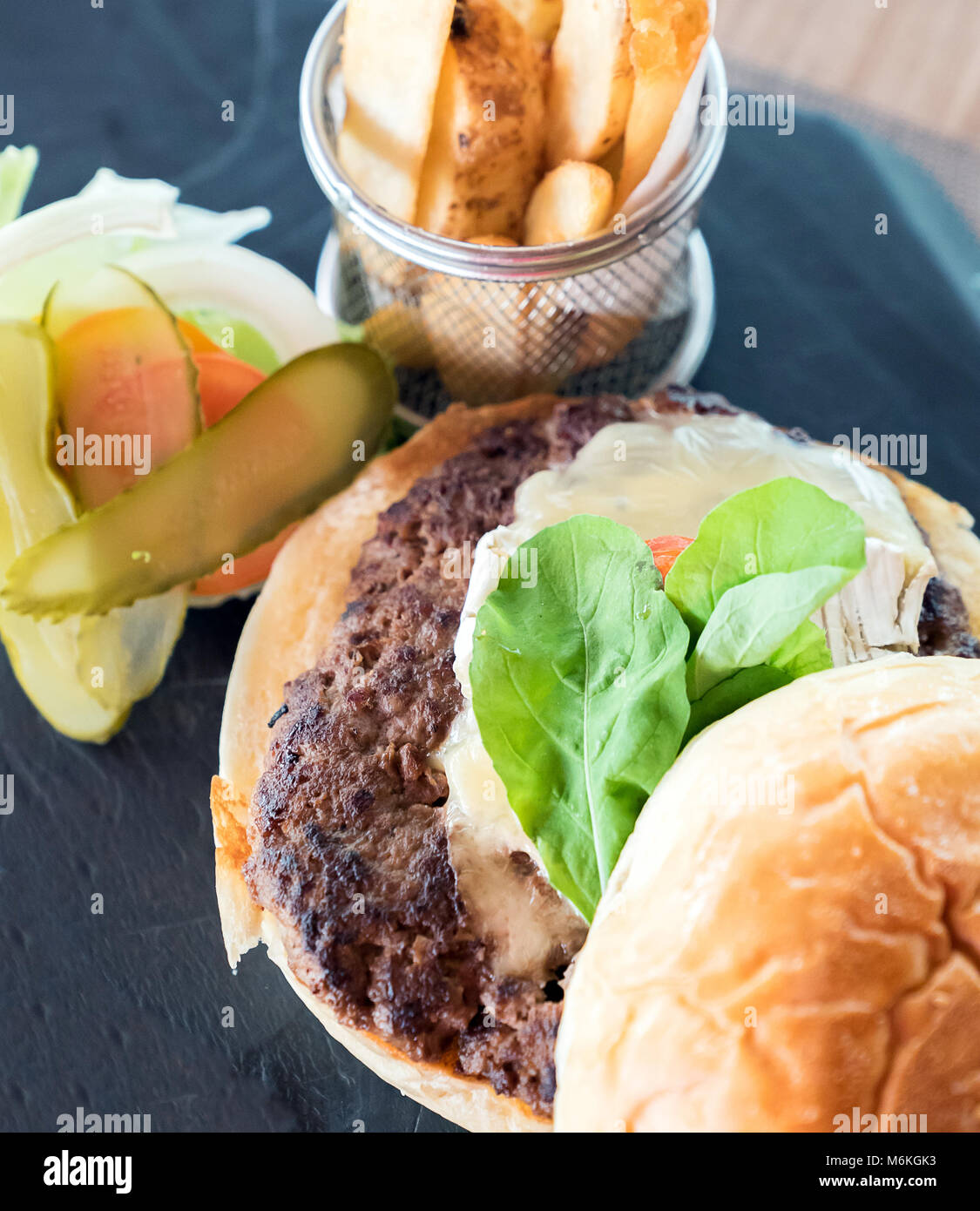 Homemade overload beef hamburger with fresh vegetables and cheese with ...