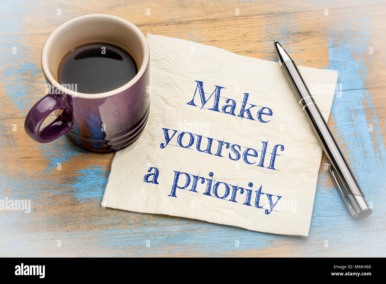 Make yourself a priority advice - handwriting on a napkin with a cup of ...