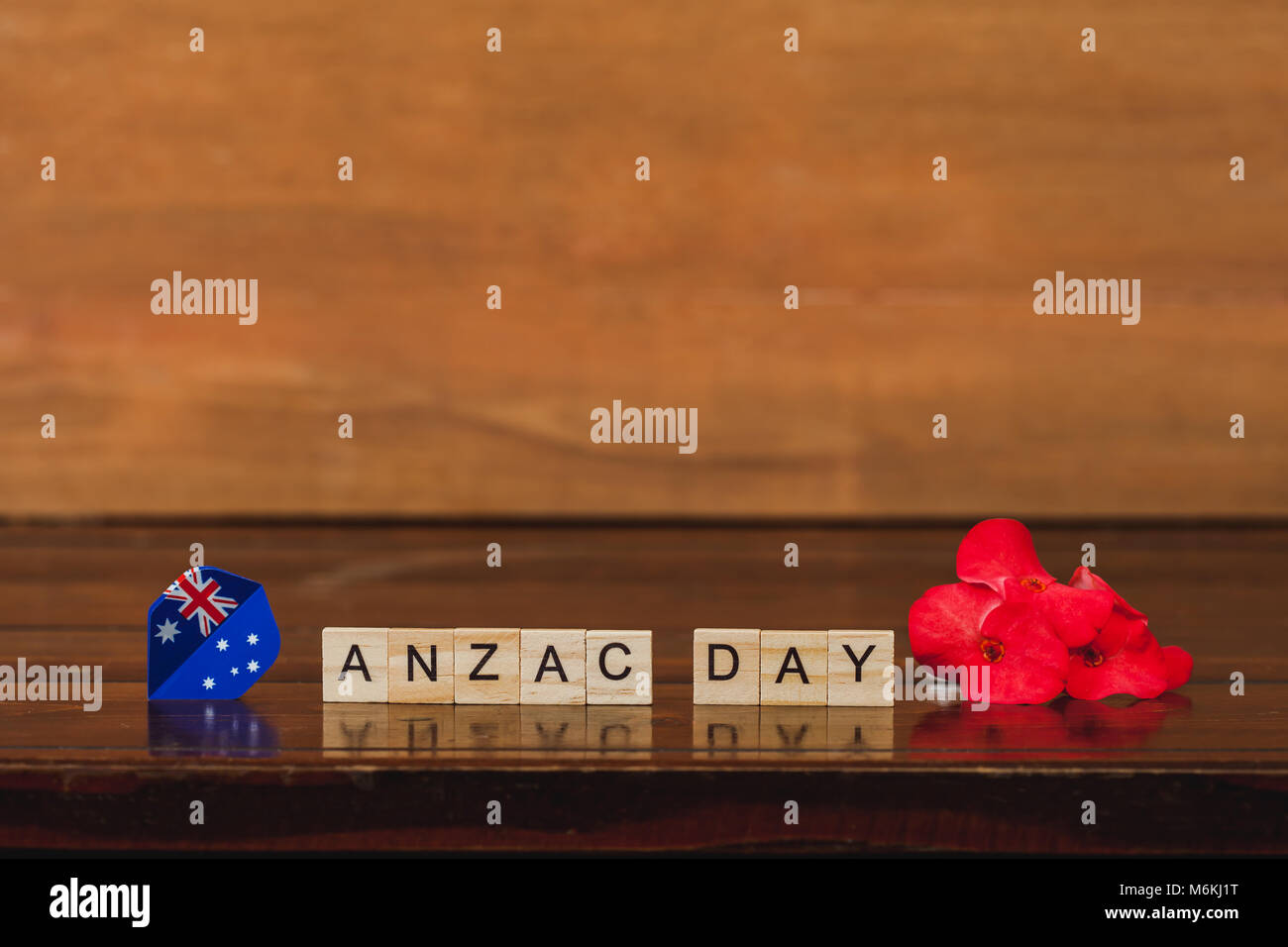 Word Anzac day on wood block with red flower on vintage wood background ...