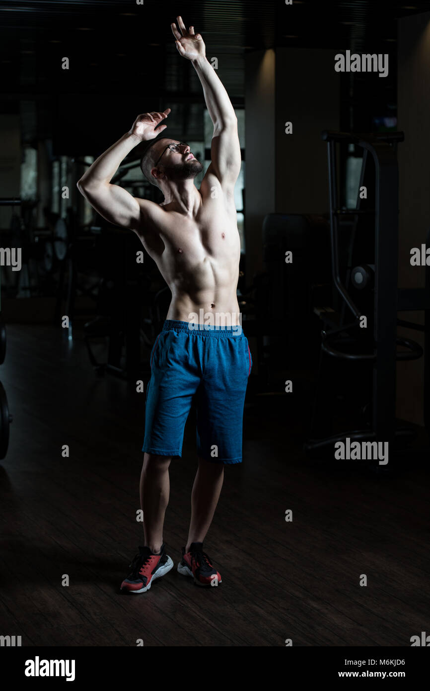 Handsome Geek Man Standing Strong In The Gym And Flexing Muscles ...