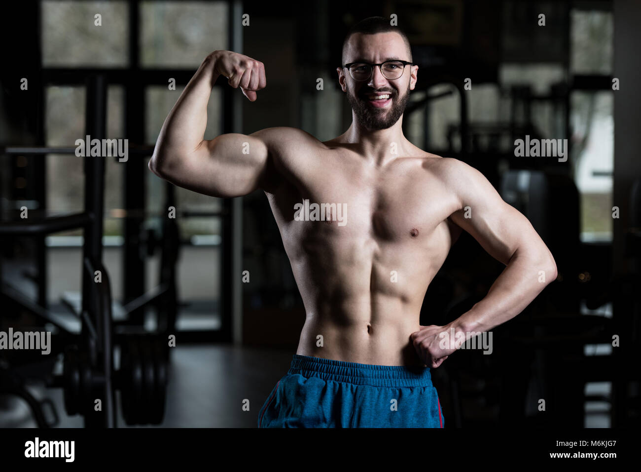 Portrait Of A Young Physically Fit Nerd Man Showing His Well Trained ...