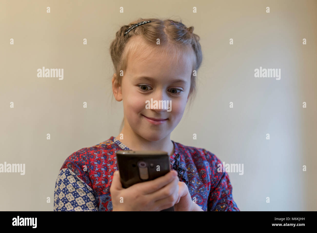 smiling little girl with smartphone Stock Photo - Alamy