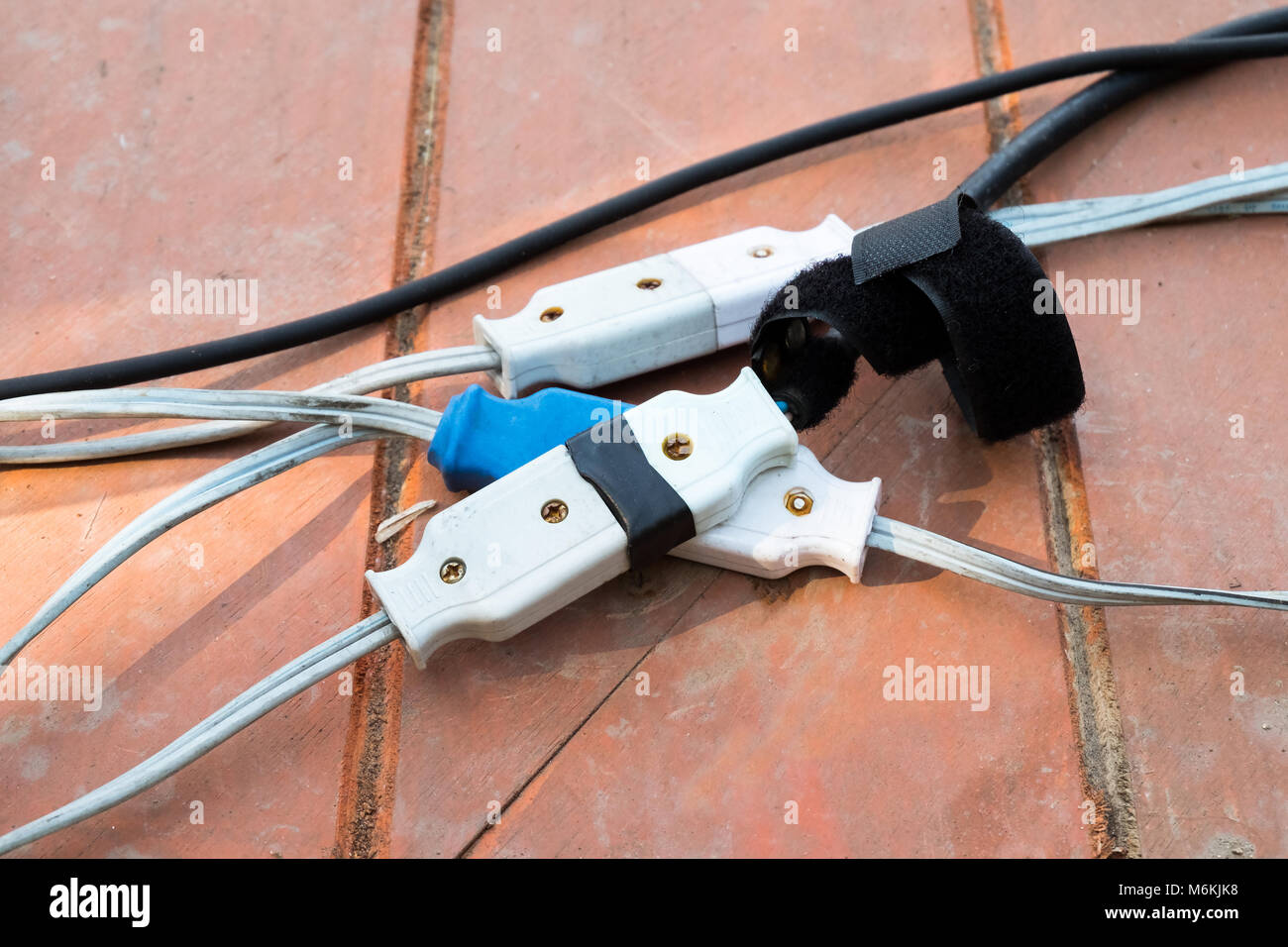 Electricity line plug in to outlet on walkway Stock Photo - Alamy