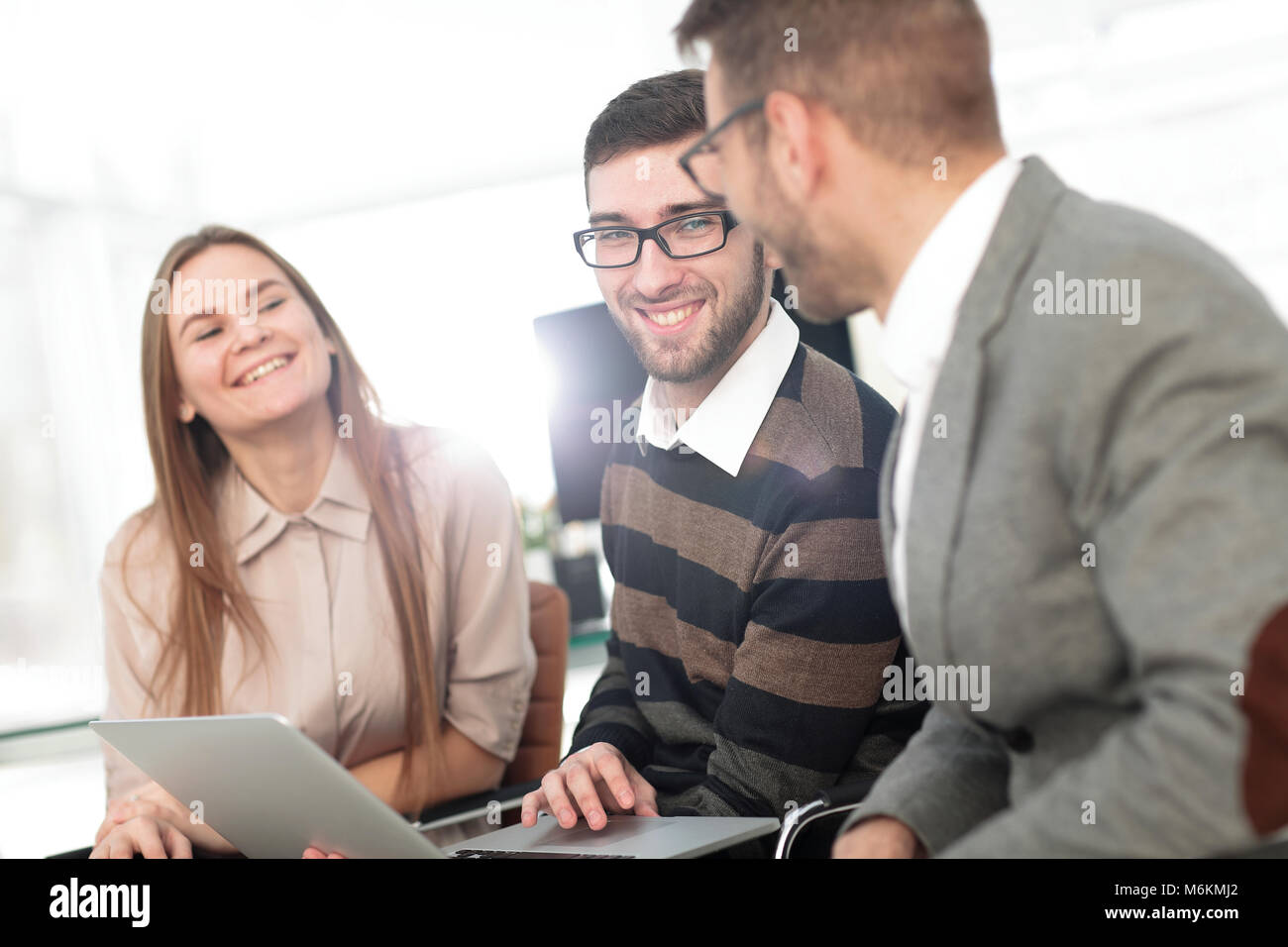 Three happy employees working on line with a tablet Stock Photo - Alamy