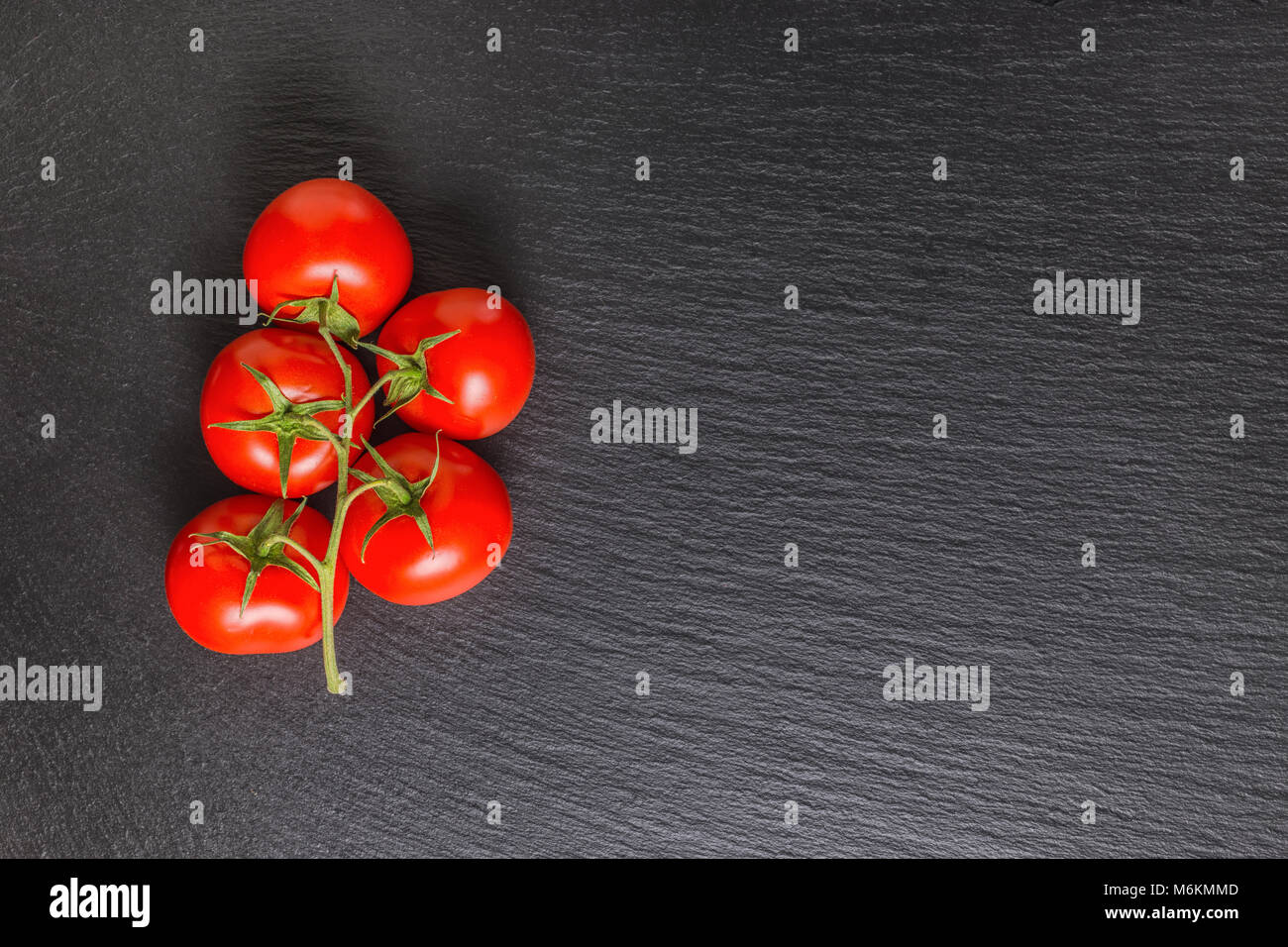 view from above of beautiful red tomatoes on black slate background ...