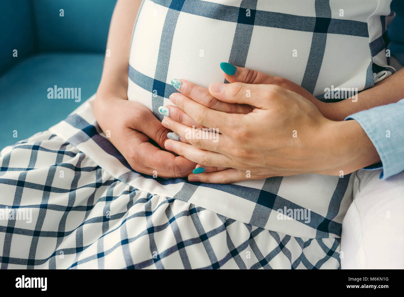 Close-up shot of the parent hands softly touching the belly of pregnant ...